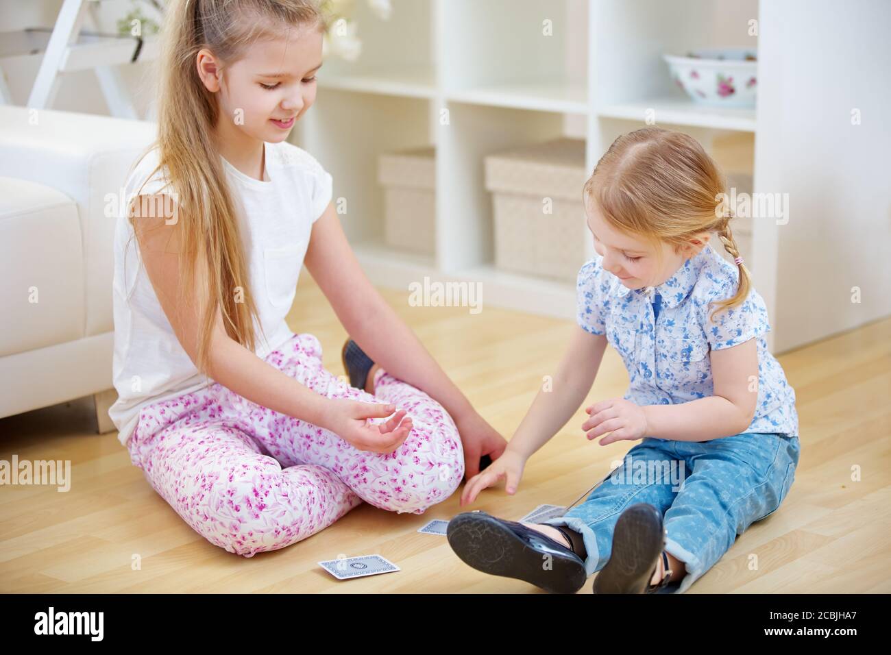 Two siblings play cards together at home Stock Photo - Alamy