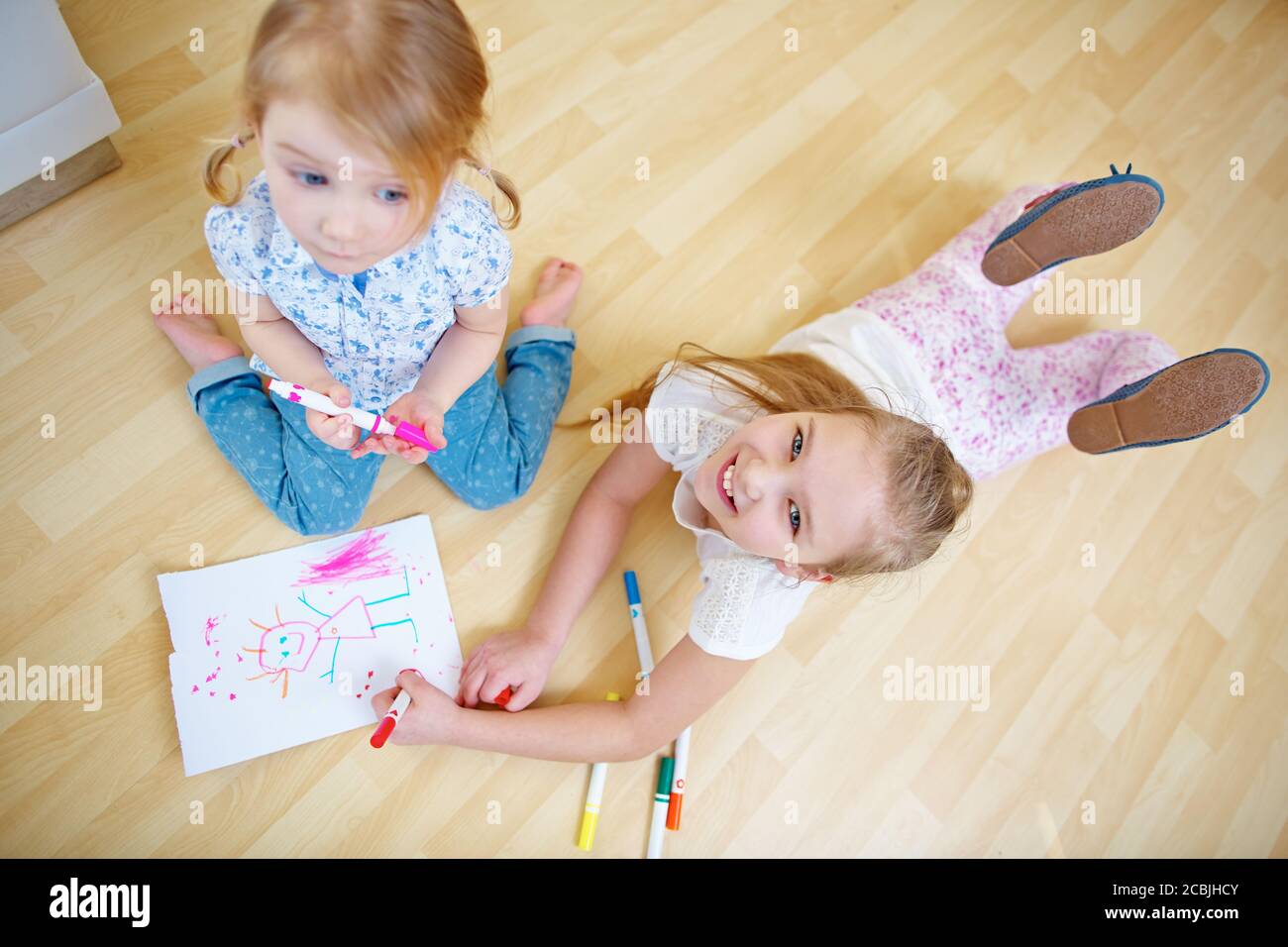 Two children from above painting a picture with felt-tip pens Stock ...