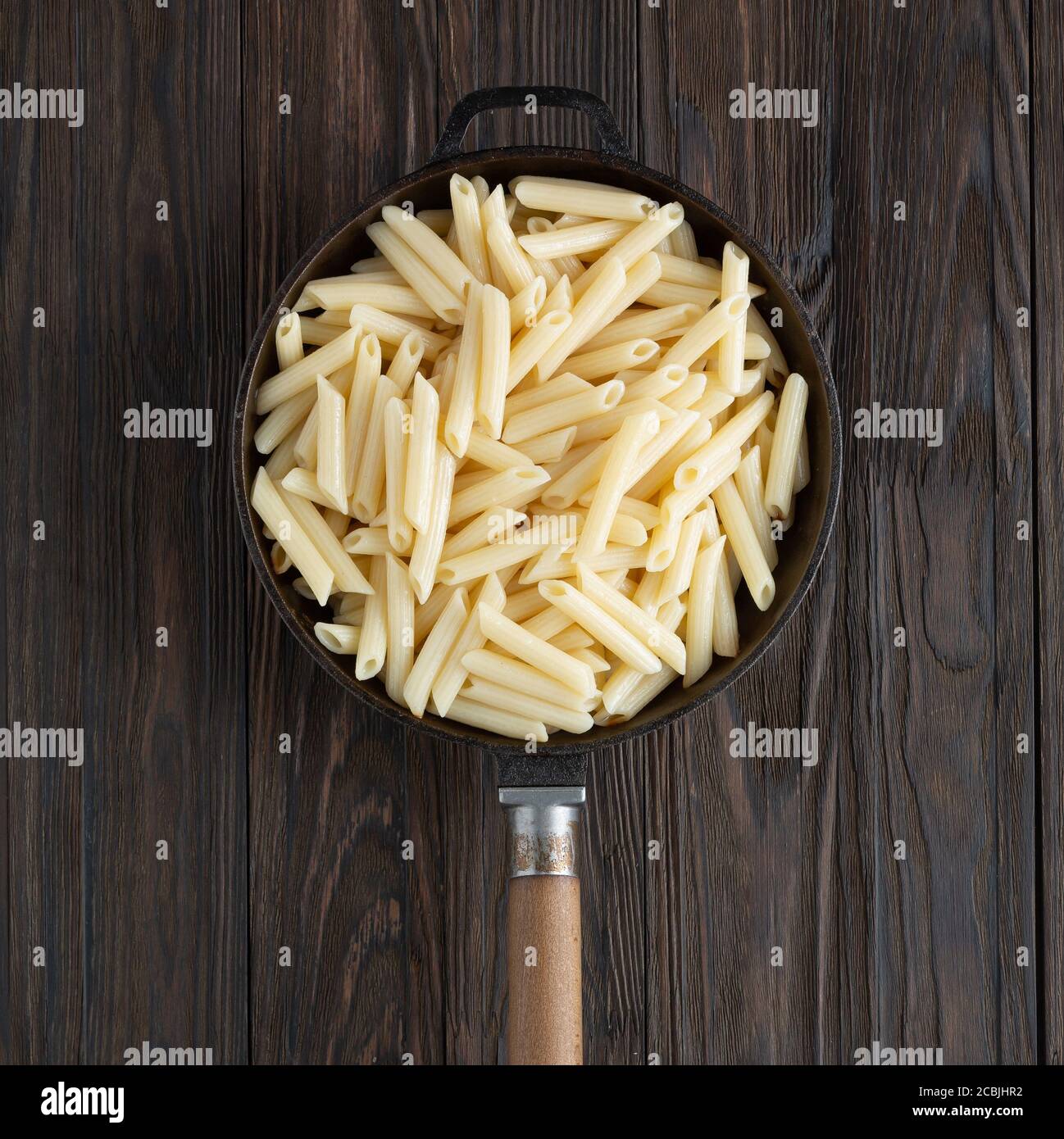 Penne Italian pasta in a frying pan, rustic style.top view Stock Photo ...