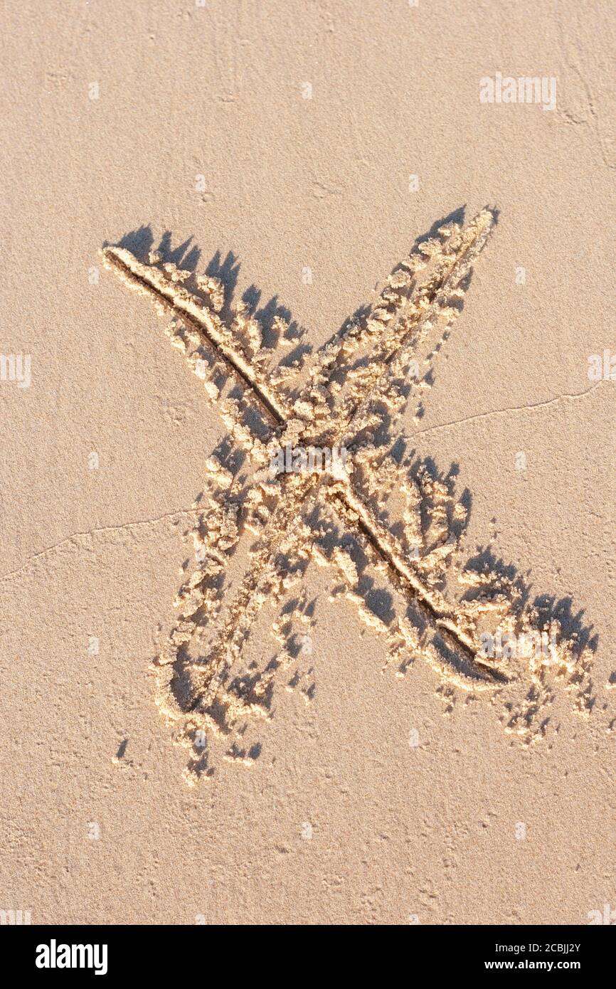 X - Alphabet letter written on sand Stock Photo - Alamy
