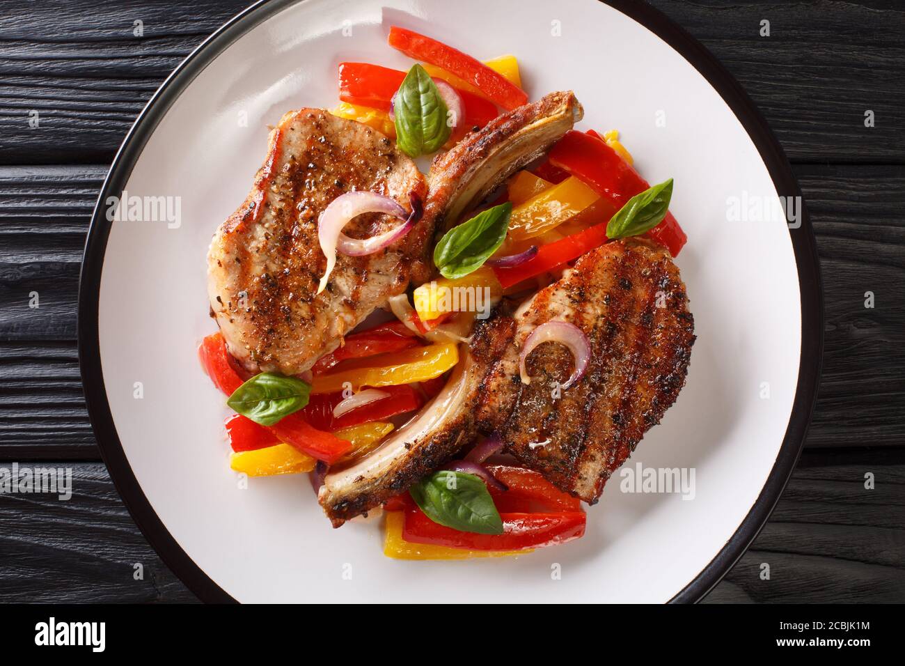 Restaurant food grilled pork chop with warm bell pepper salad close-up ...