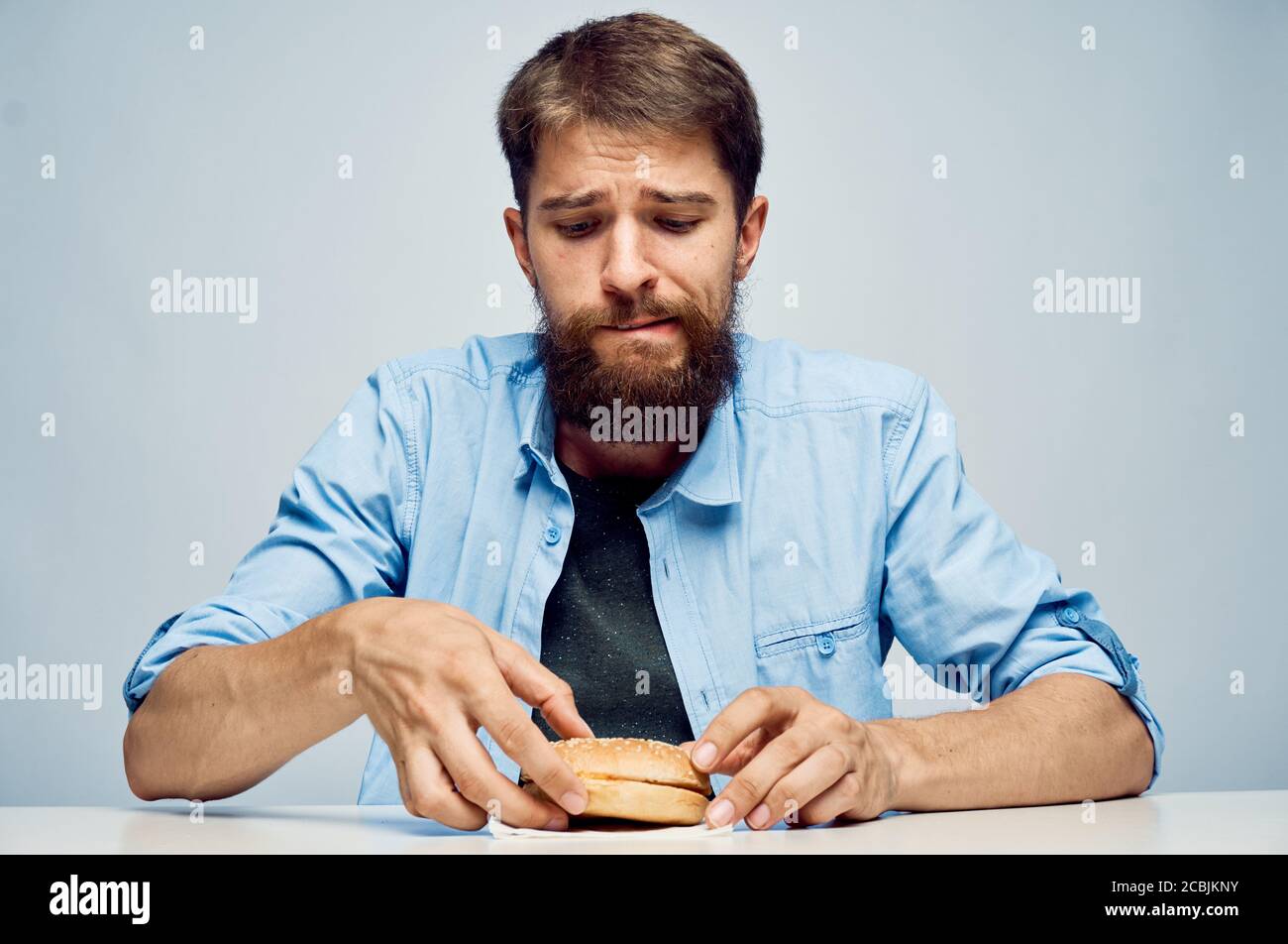 man sitting at the table hamburger diet food lifestyle eating Stock ...