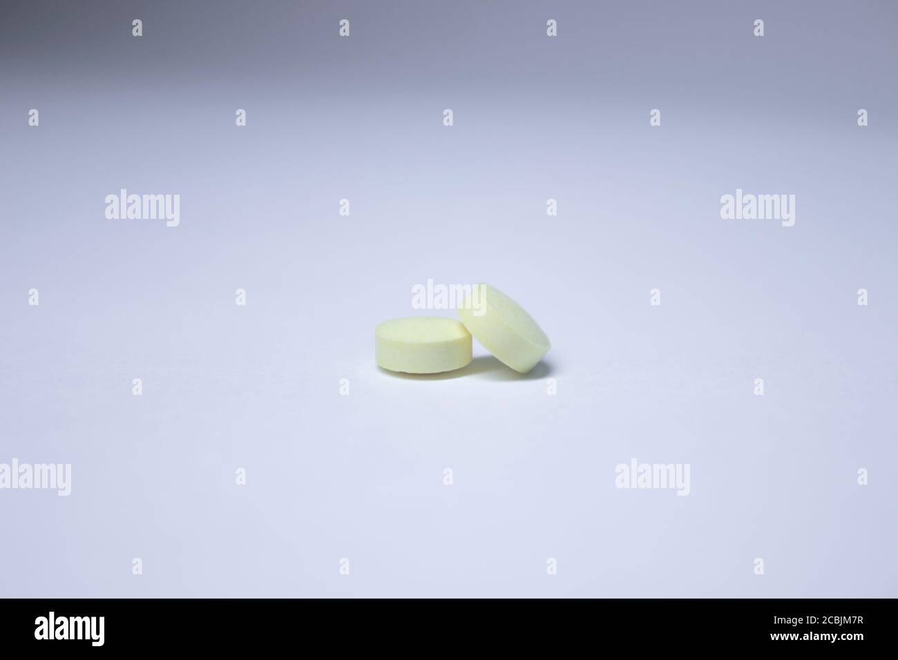 yellow tablet - pill on a white background. medicine and disease ...