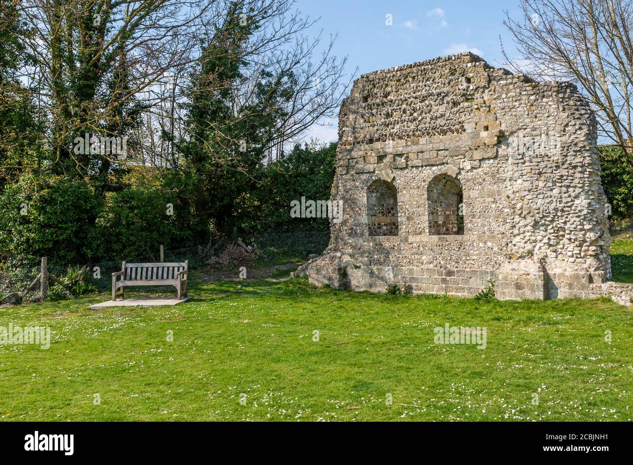An empty bench next to part of Lewes Priory ruins Stock Photo - Alamy