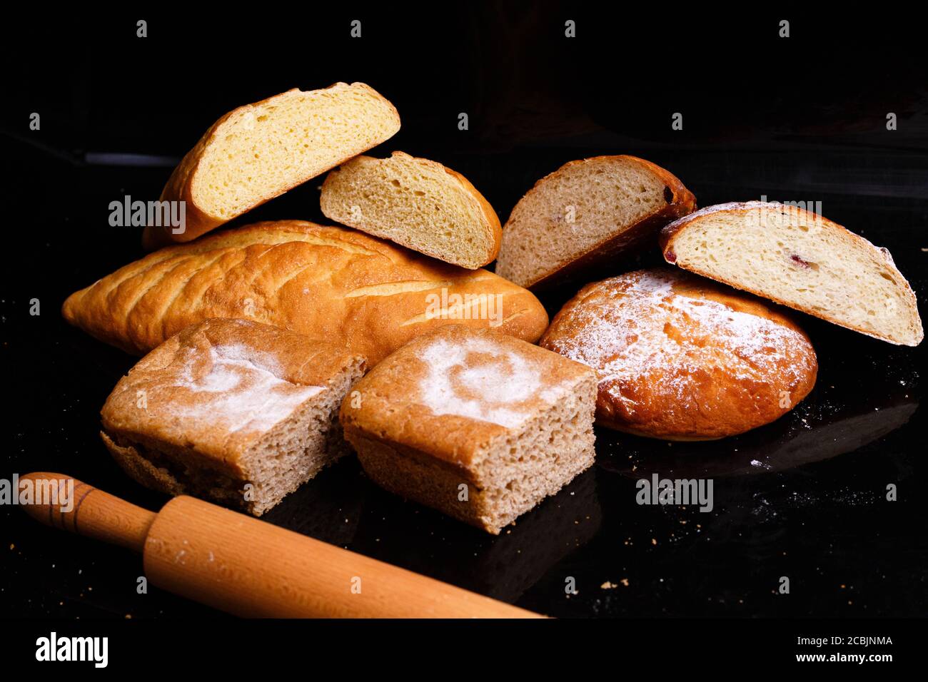 Baking on a black background with a rolling pin. Lots of pastries and ...