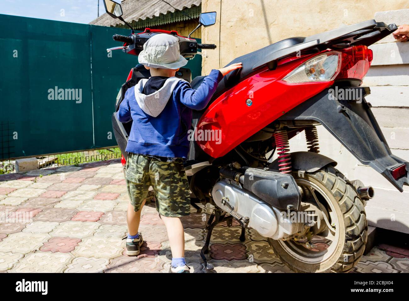 pictured in the photo a little boy is sitting on a red motorcycle Stock ...