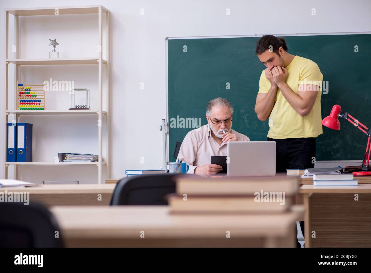 Old teacher and young student in the classroom Stock Photo - Alamy
