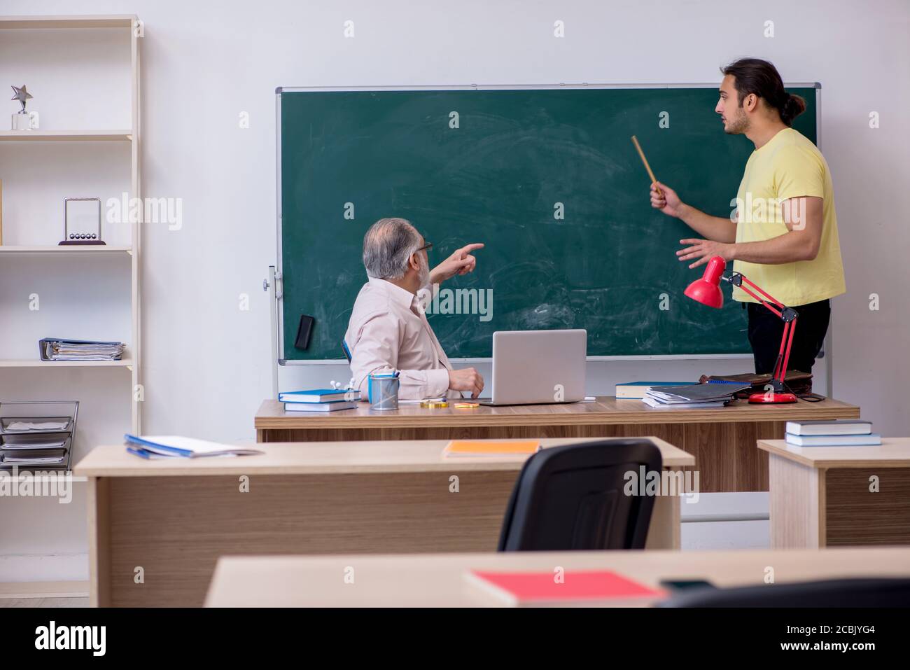 Old teacher and young student in the classroom Stock Photo - Alamy
