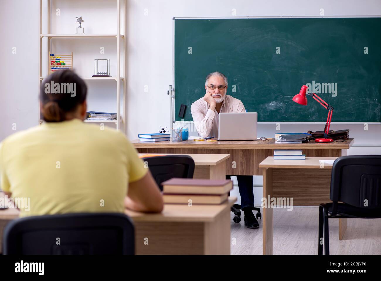 Old teacher and young student in the classroom Stock Photo - Alamy