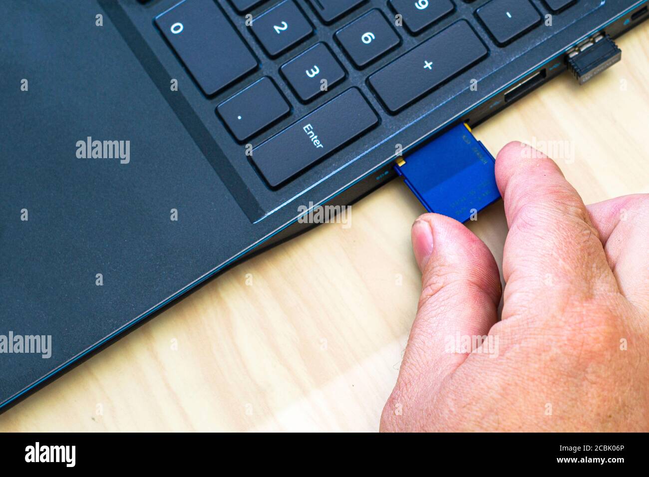 a man's hand inserting a flash card into a laptop connector Stock Photo ...