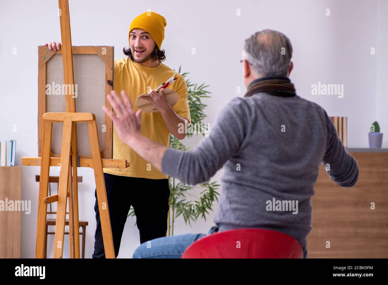 Young portraitist and old model Stock Photo - Alamy
