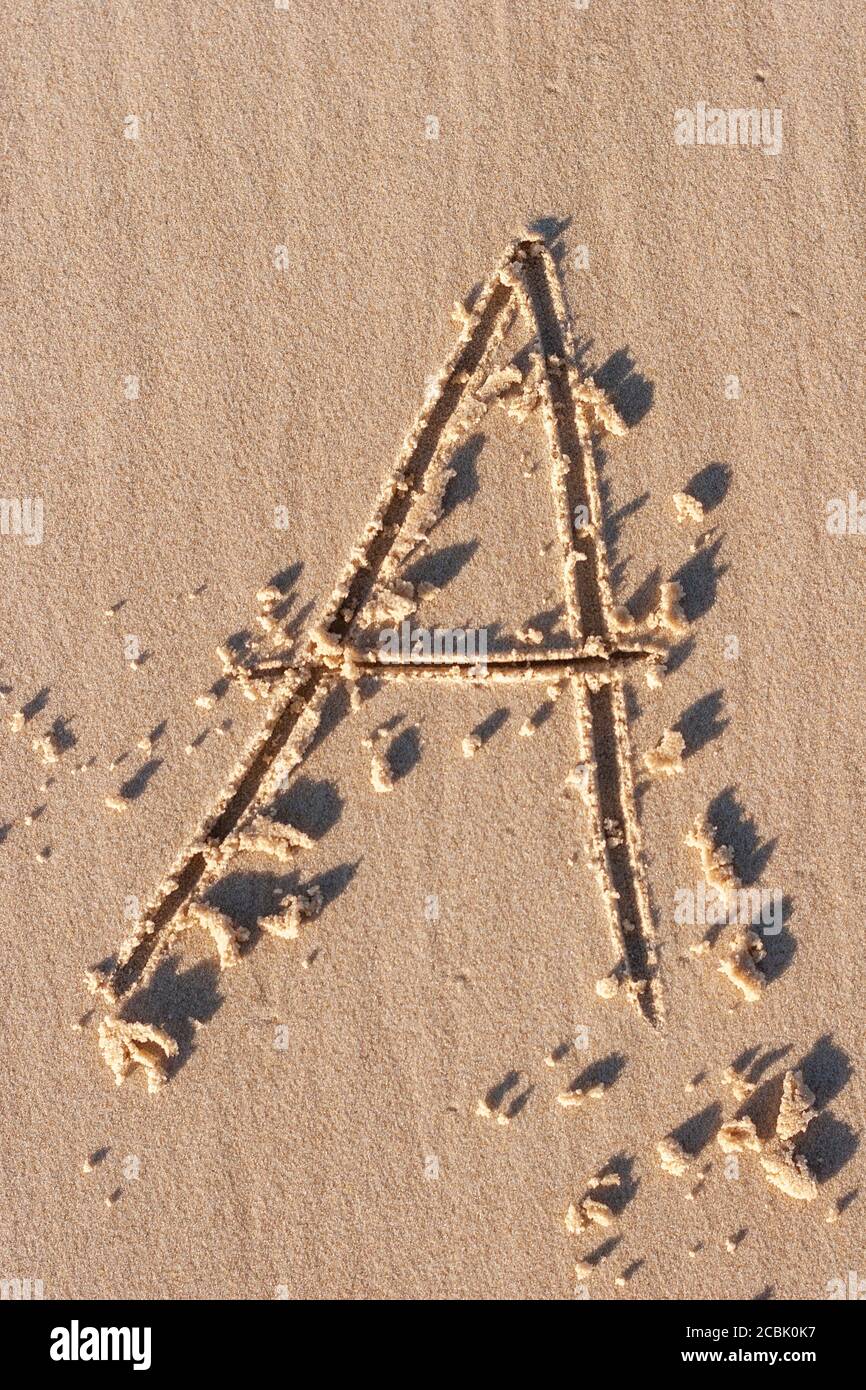 A - Alphabet letter written on sand Stock Photo - Alamy
