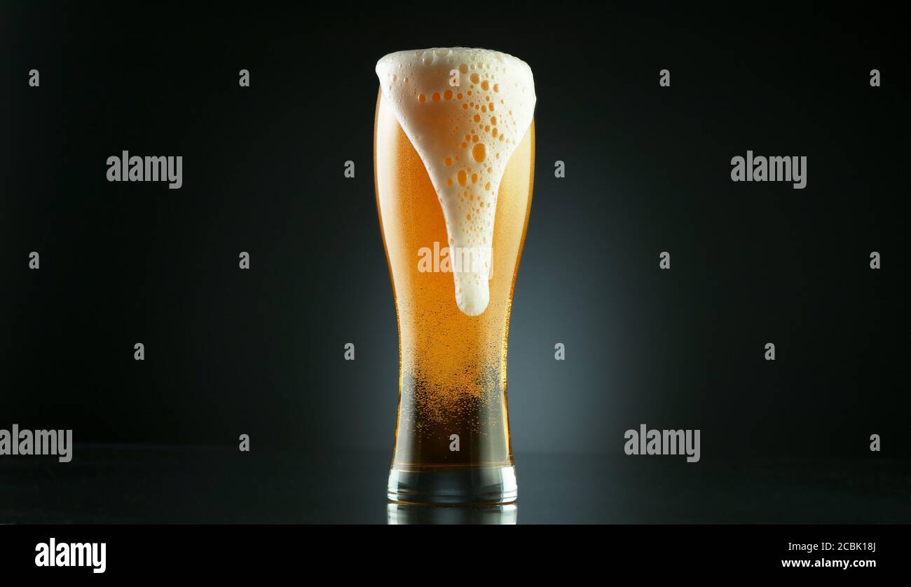 Freeze motion of pouring beer into glass pint, isolated on black ...