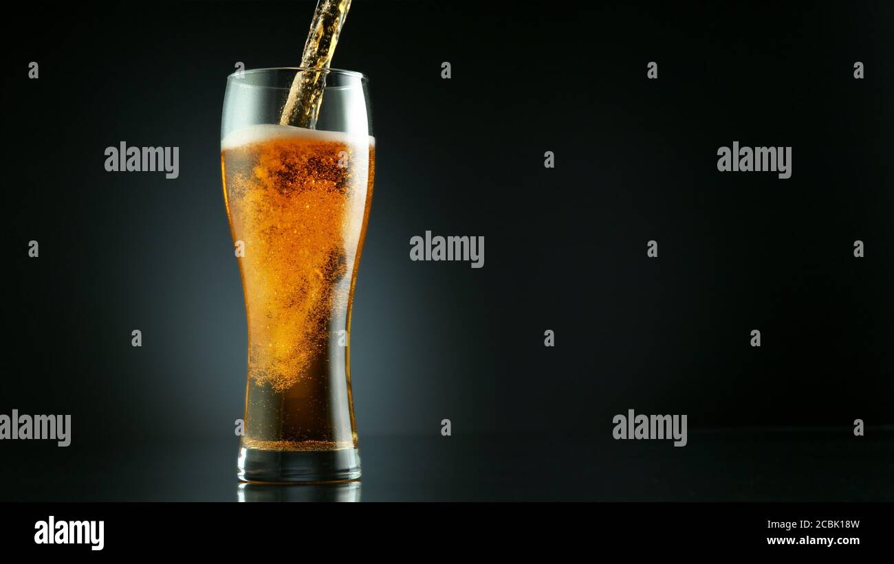 Freeze motion of pouring beer into glass pint, isolated on black ...