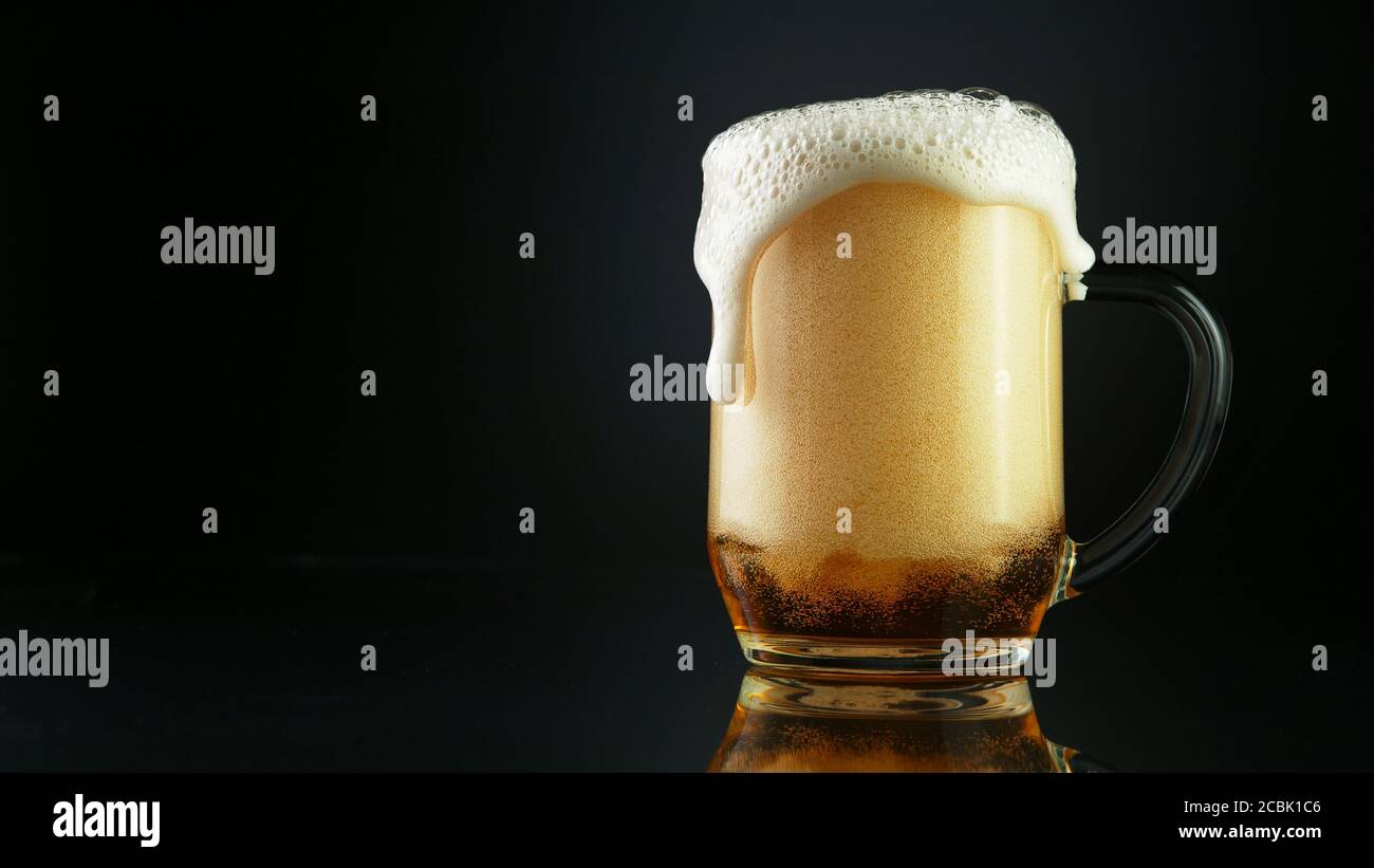 Beer foam overflowing from glass pint, isolated on black background ...