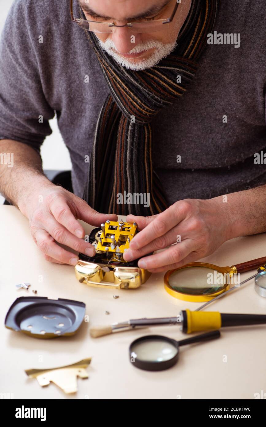 Old watchmaker working in the workshop Stock Photo - Alamy