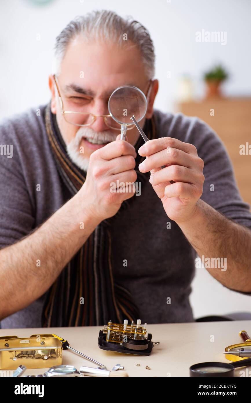 Old watchmaker working in the workshop Stock Photo - Alamy