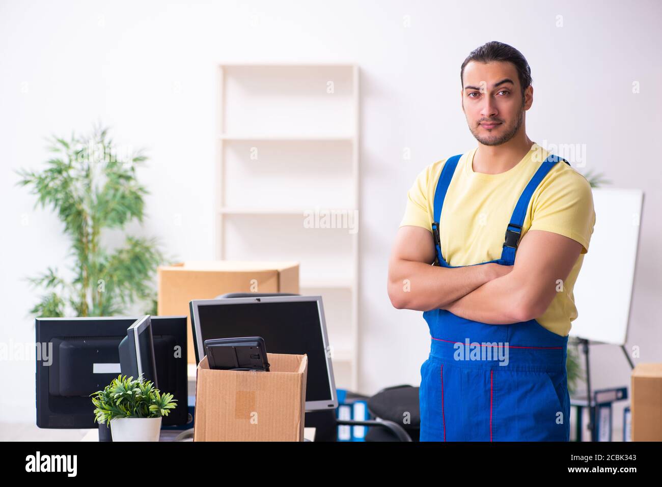 Young male contractor in the moving concept Stock Photo - Alamy