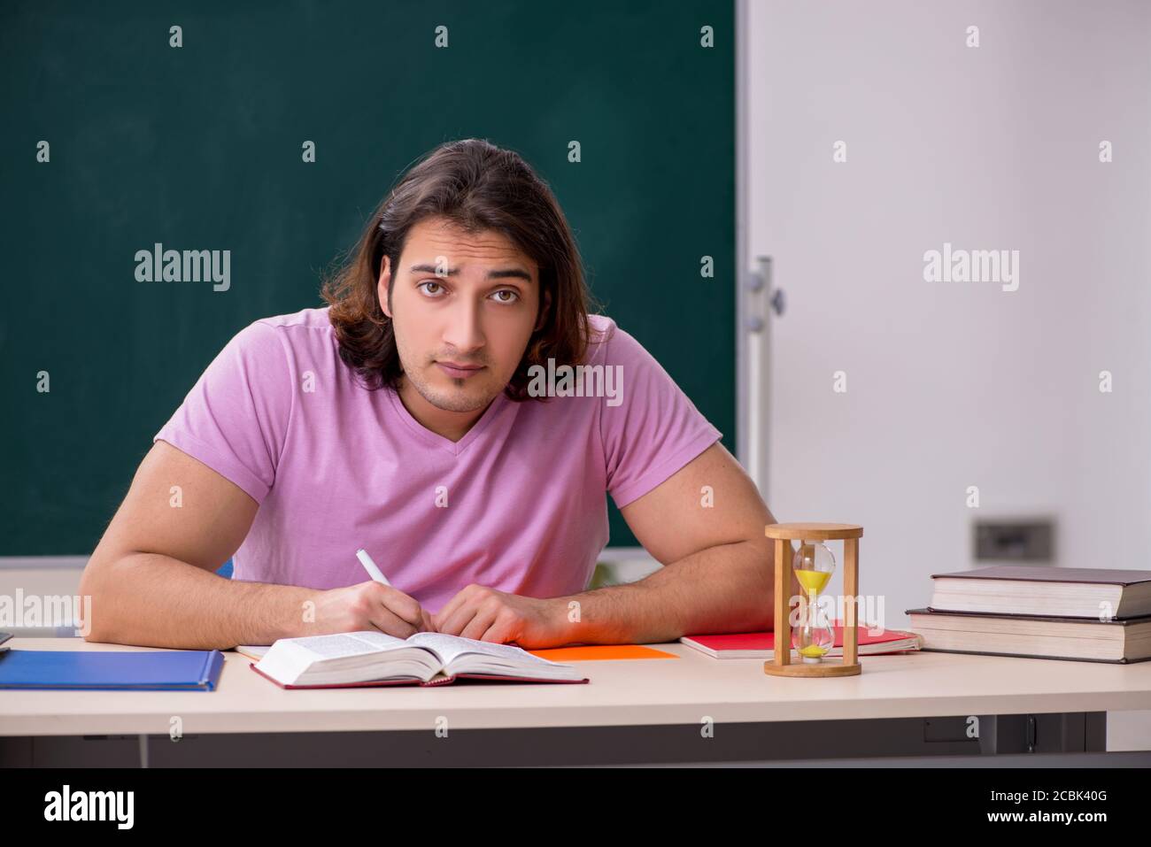 Young student in the classroom at time management concept Stock Photo ...
