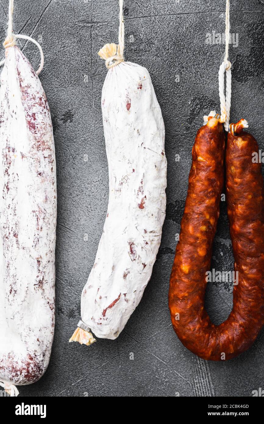 Spanish salami from a rack at market on grey textured background, flat ...