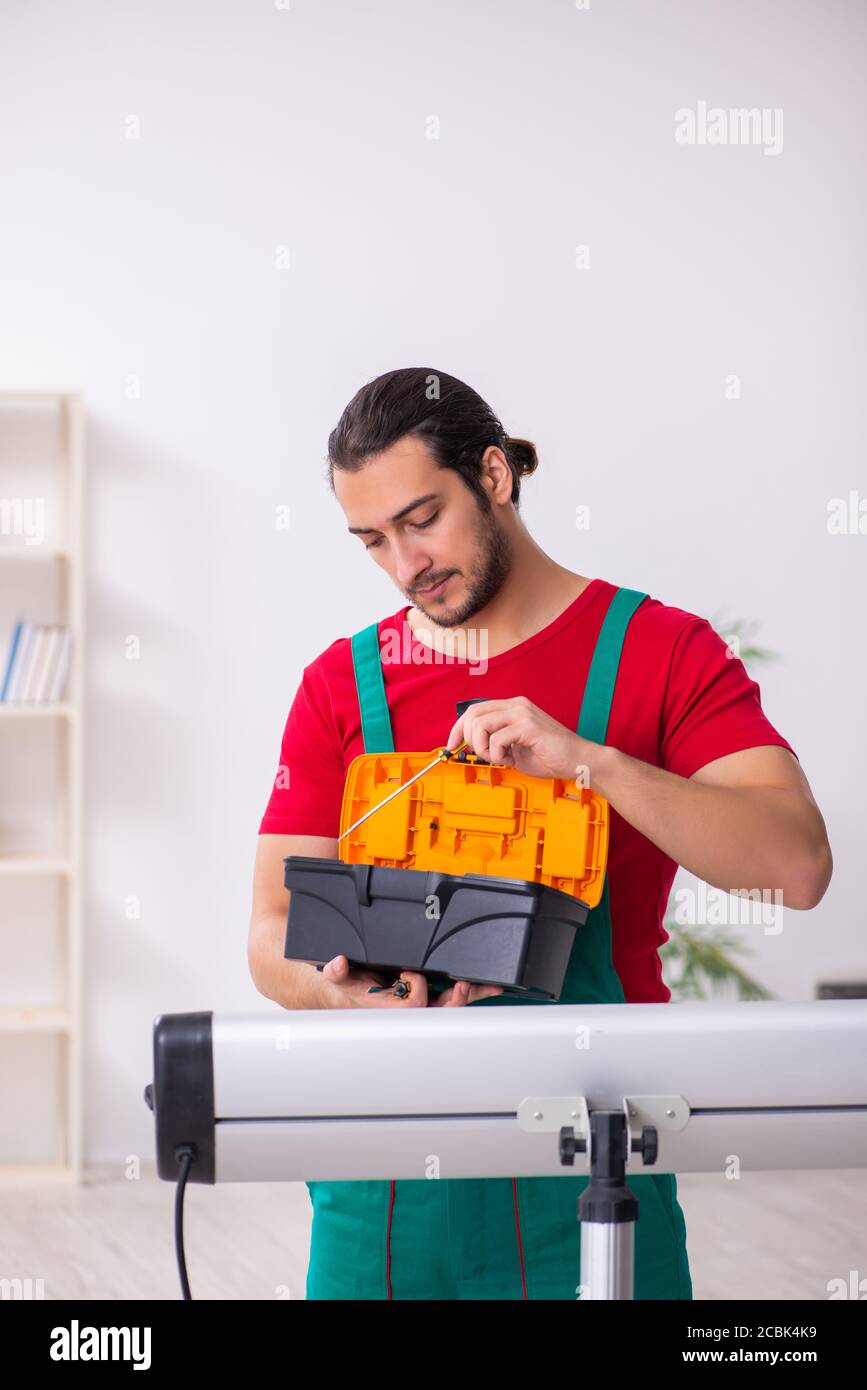 Young male contractor repairing heater Stock Photo - Alamy