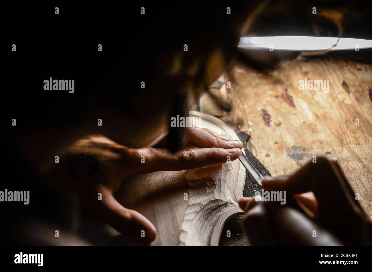 hands of artisan woman violin maker luthier working in the back table ...