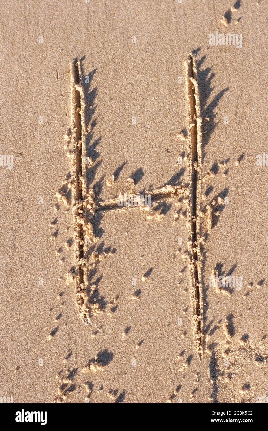 H - Alphabet letter written on sand Stock Photo - Alamy
