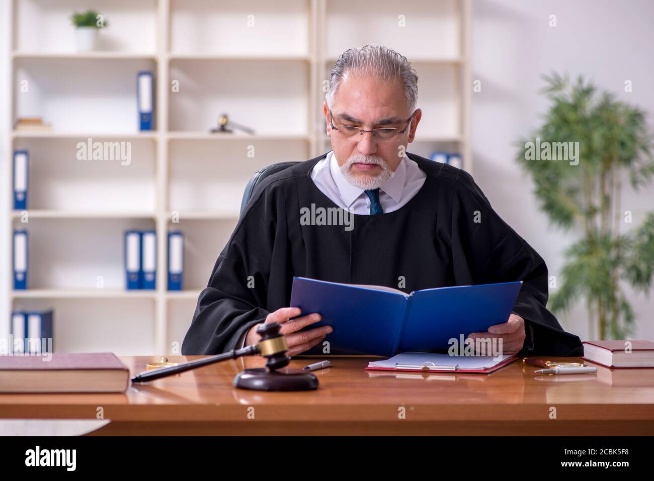 Old male judge working in the courthouse Stock Photo - Alamy