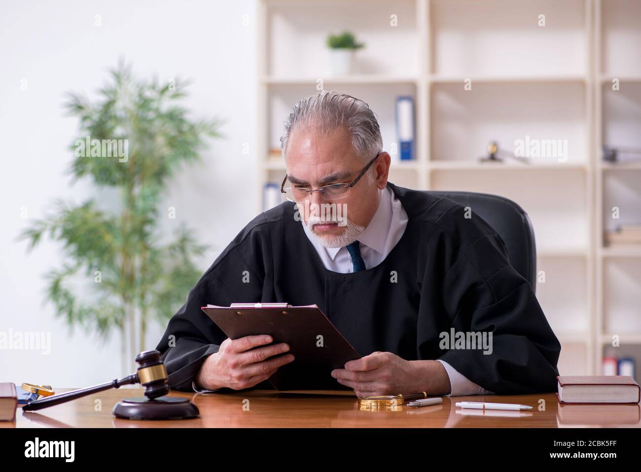 Old male judge working in the courthouse Stock Photo - Alamy