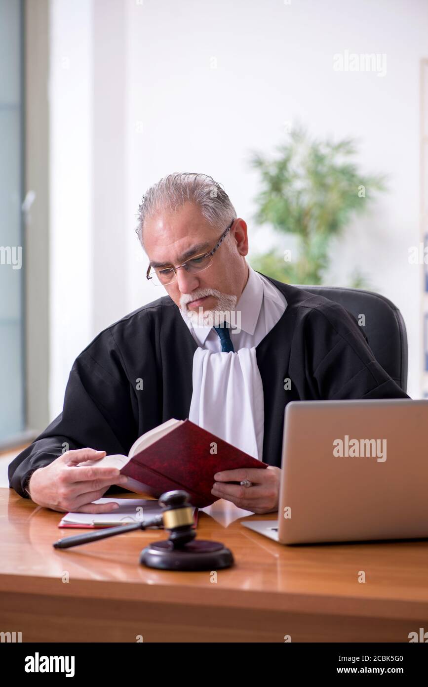 Old male judge working in the courthouse Stock Photo - Alamy