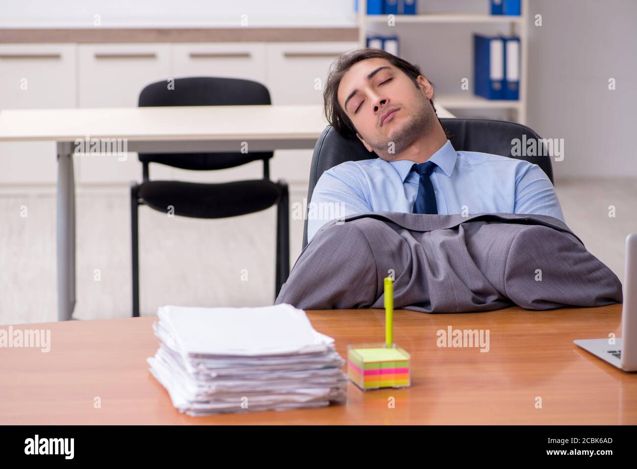 Young employee sleeping in the office Stock Photo - Alamy