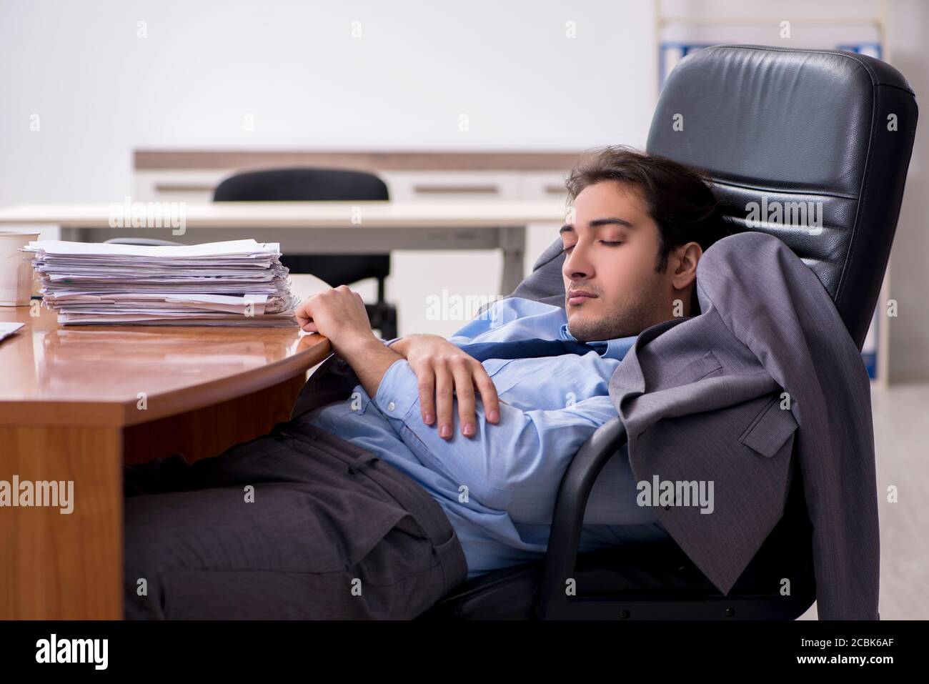 Young employee sleeping in the office Stock Photo - Alamy