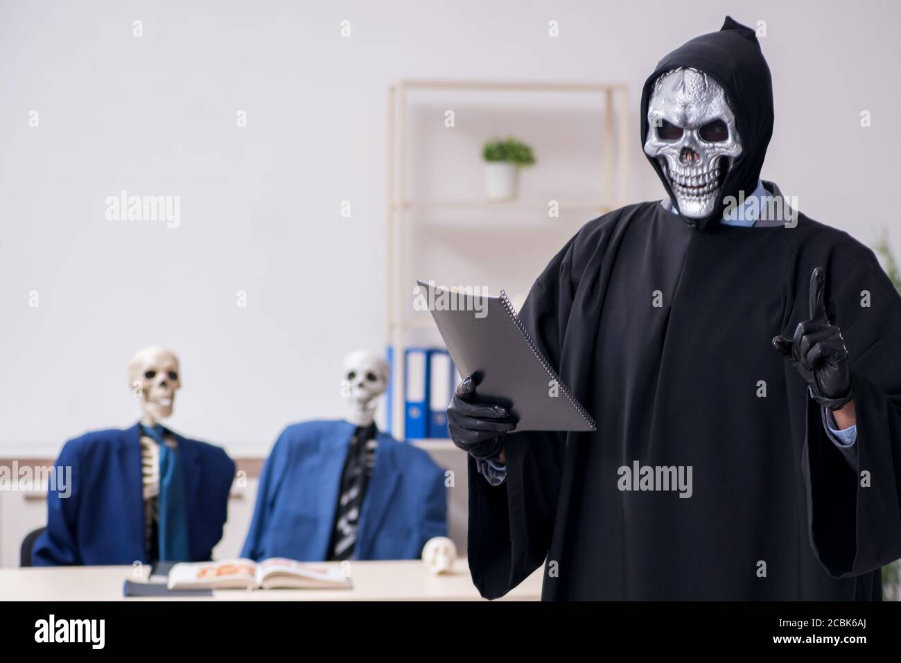 Funny business meeting with the devil and skeletons Stock Photo - Alamy