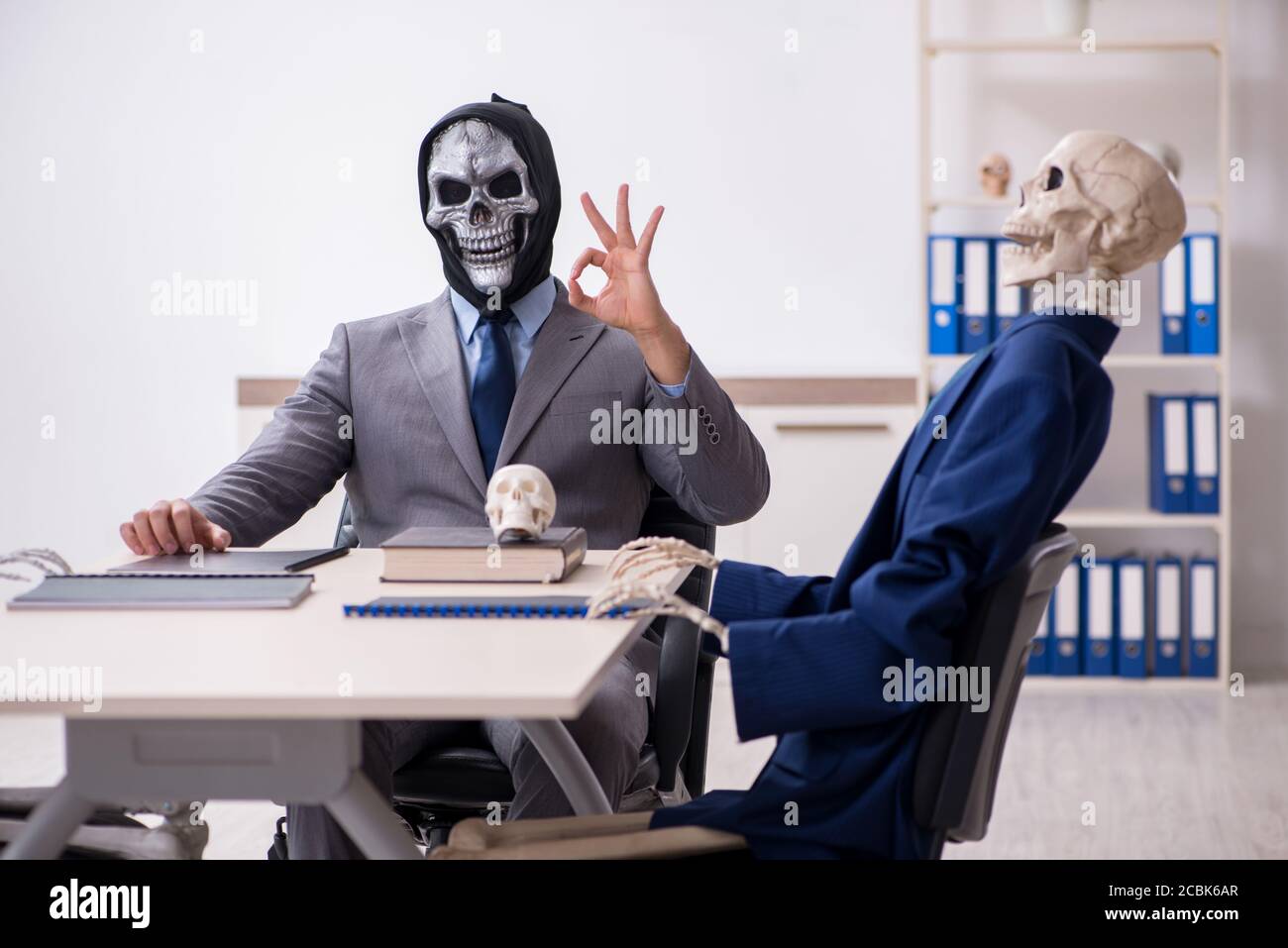 Funny business meeting with the devil and skeletons Stock Photo - Alamy