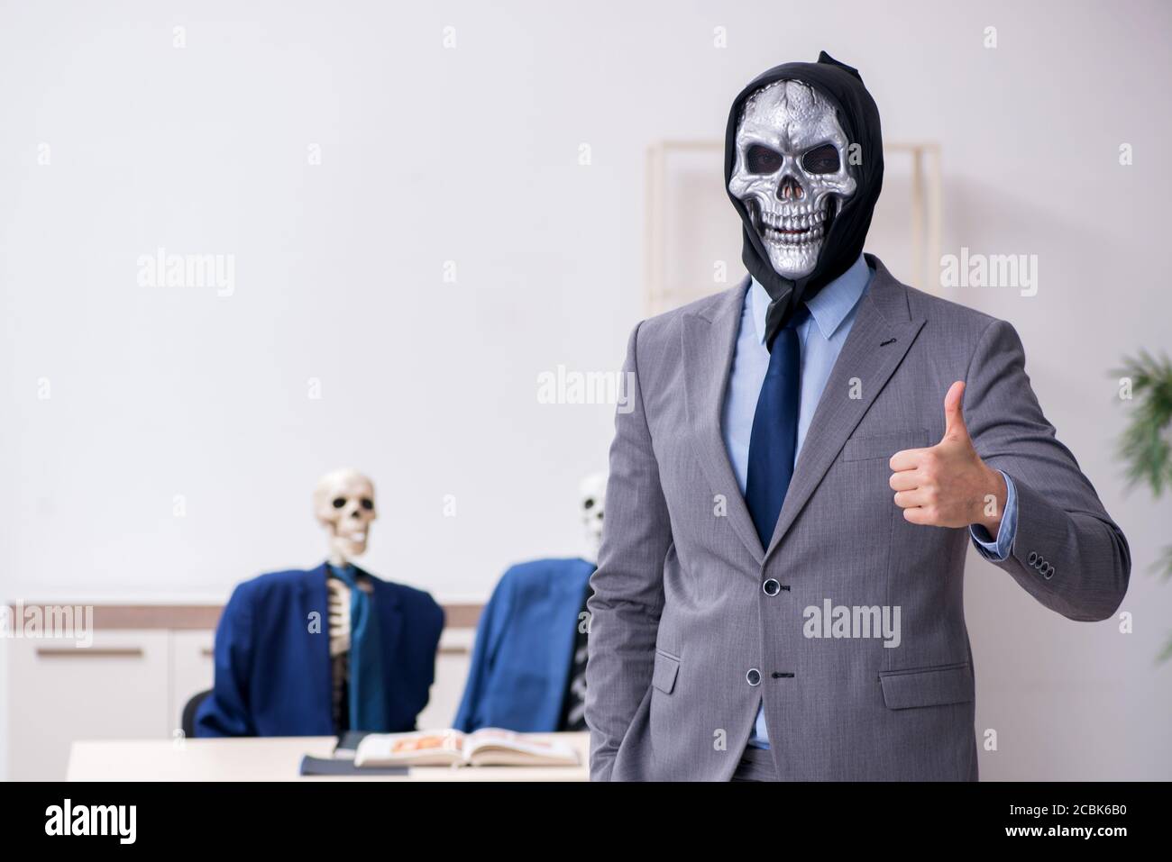 Funny business meeting with the devil and skeletons Stock Photo - Alamy