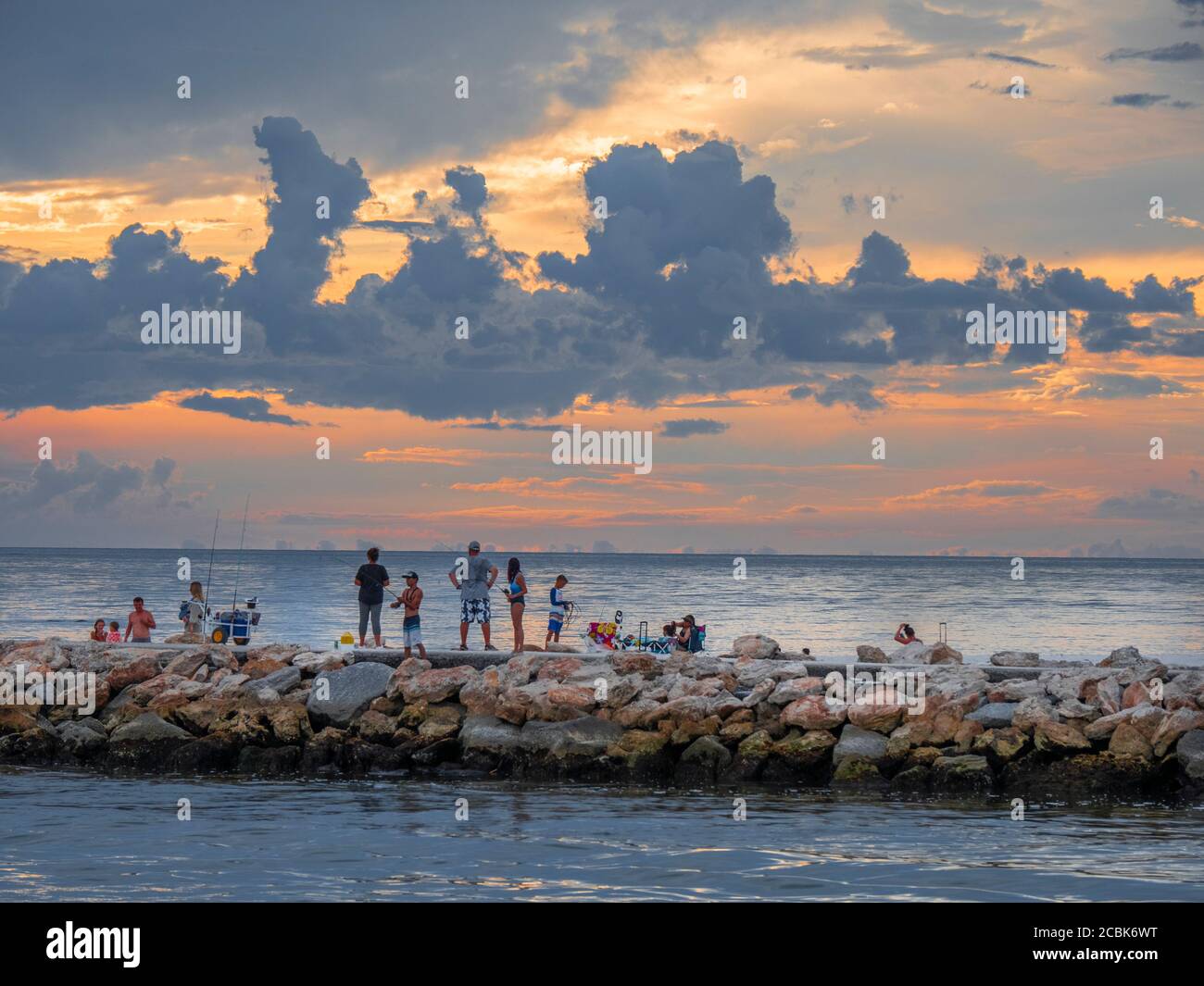 Colorful orange sky at dusk over the Gulf of Mexico at the North Jetty ...