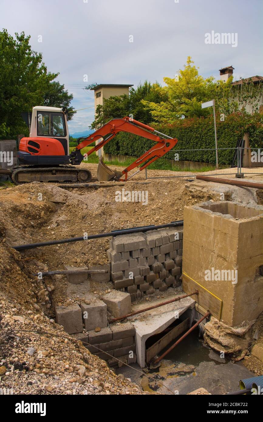 A sewer well trench & a compact crawler excavator with rotating house ...