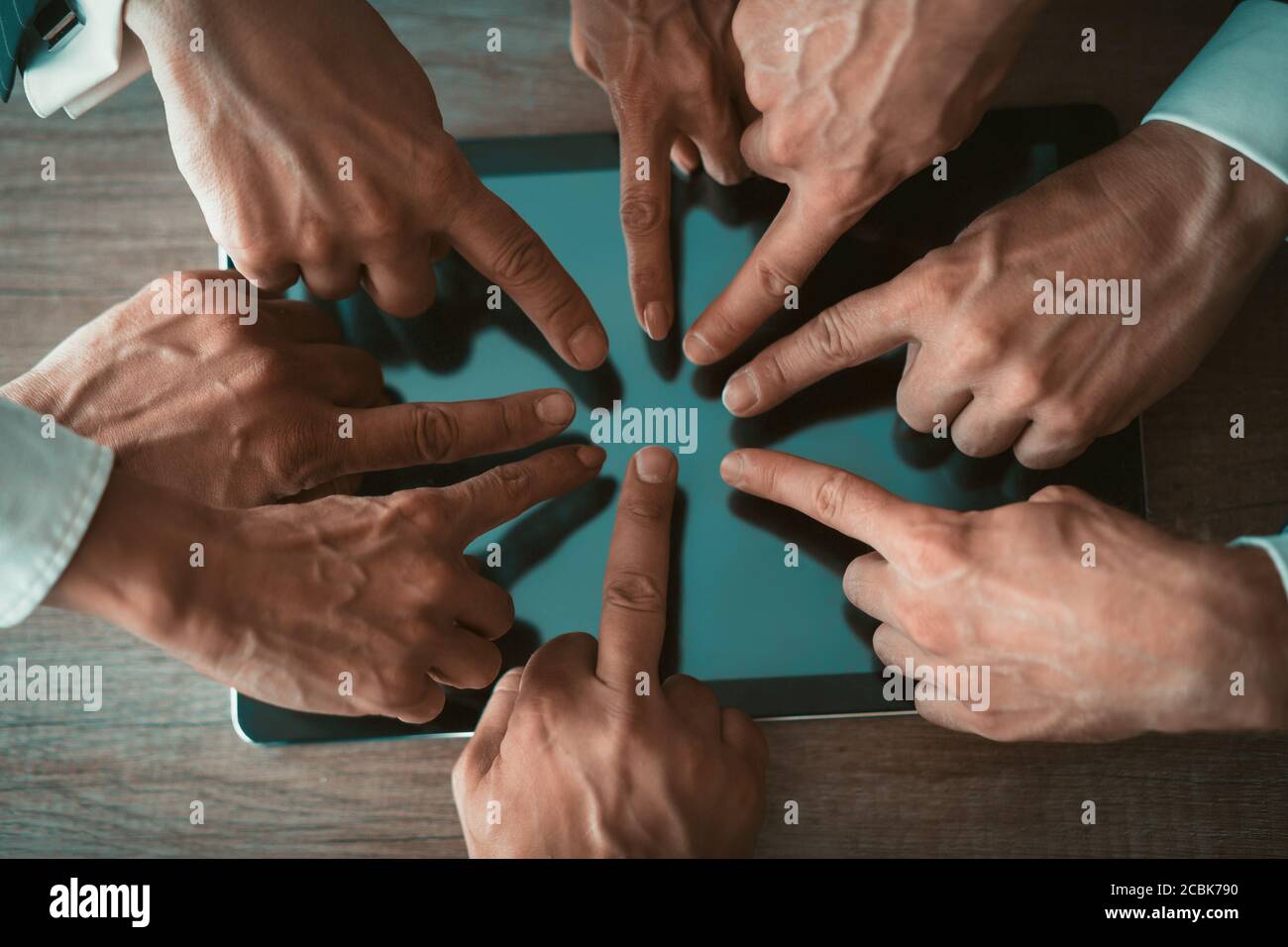 Business people hands touching screen of digital tablet on wooden table ...