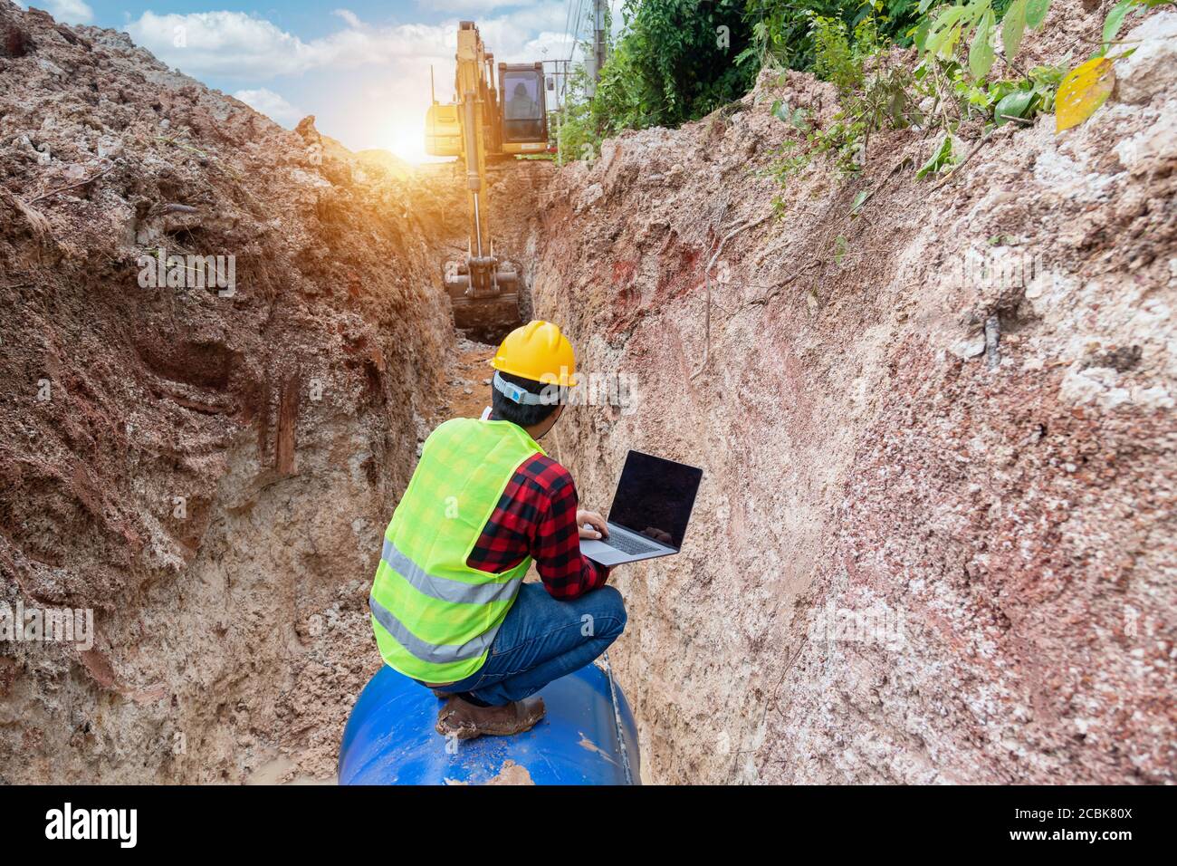 Engineer wear safety uniform use laptop examining excavation Drainage ...