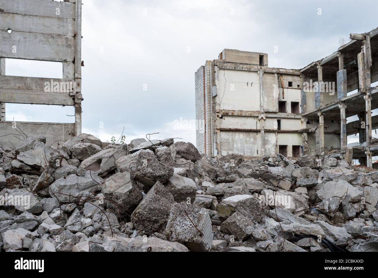 Concrete debris with rebar against the background of a destroyed ...