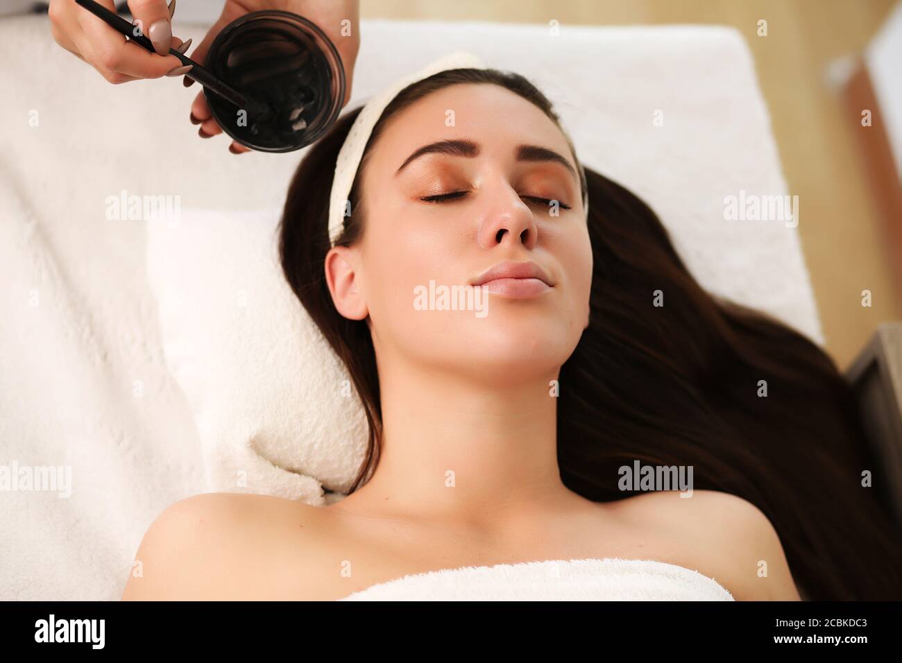 Spa concept. Young woman with nutrient facial mask in beauty salon ...
