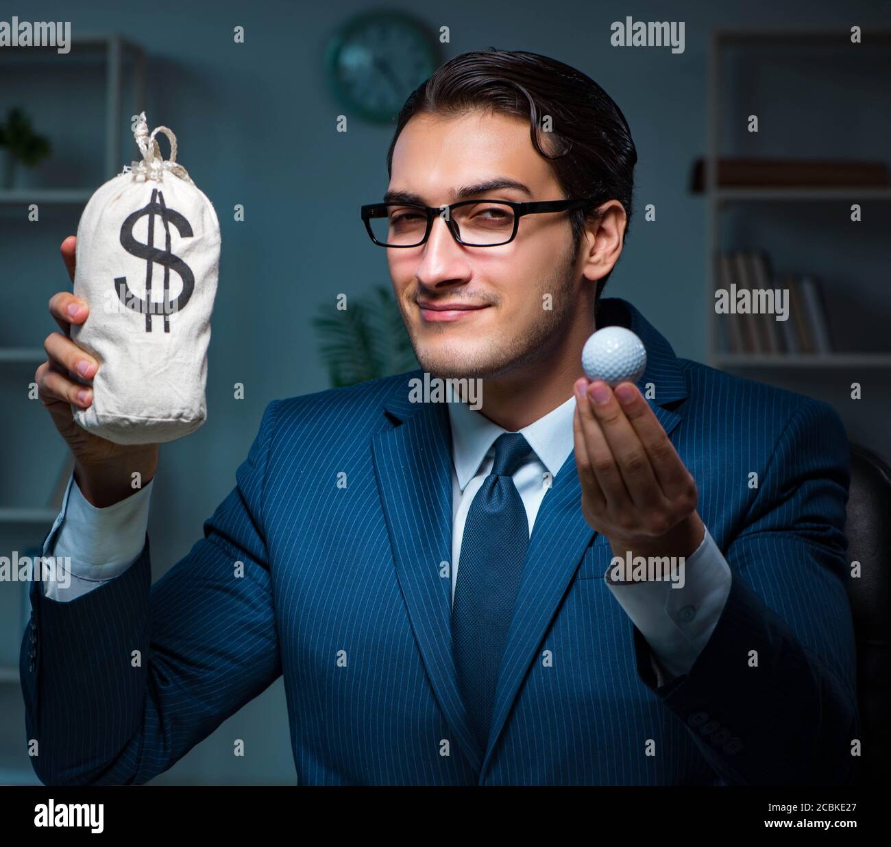 The young employee with golf ball in office Stock Photo - Alamy