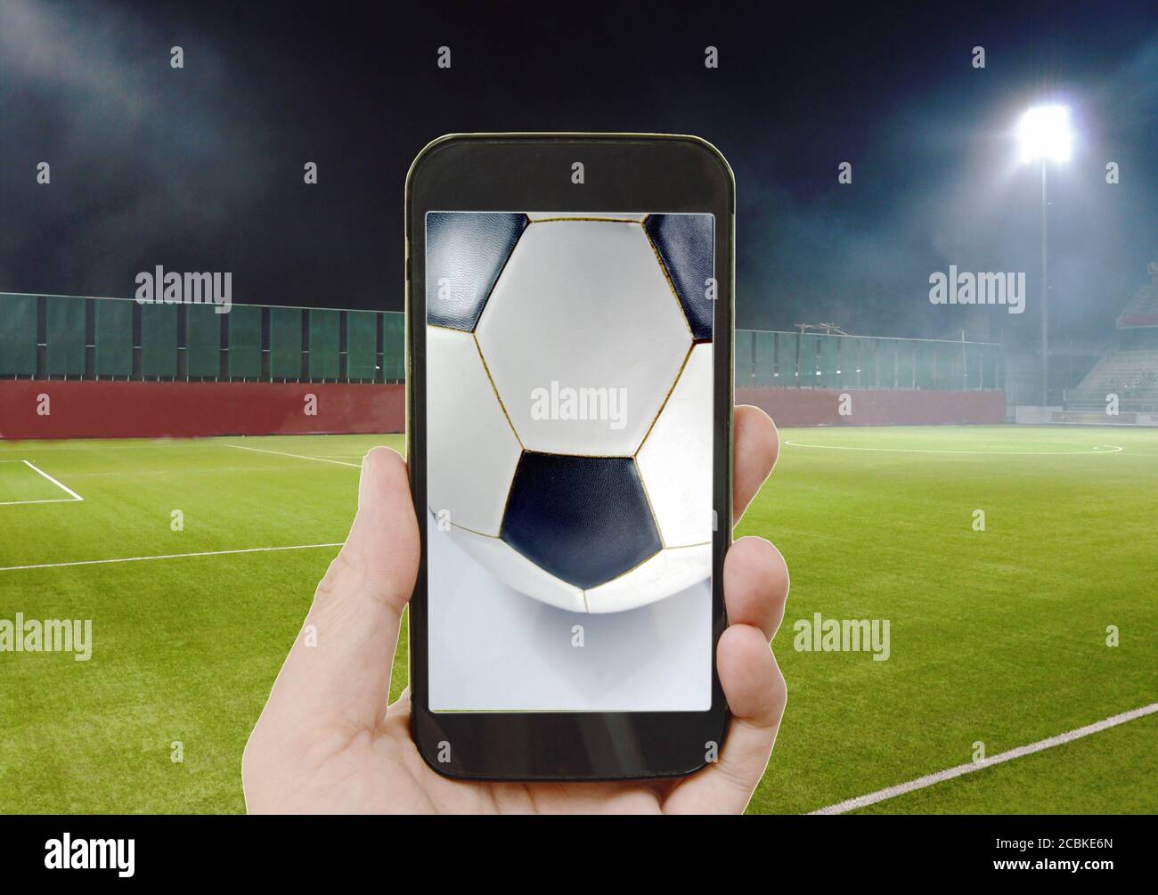 mobile phone showing football on screen in stadium background Stock ...