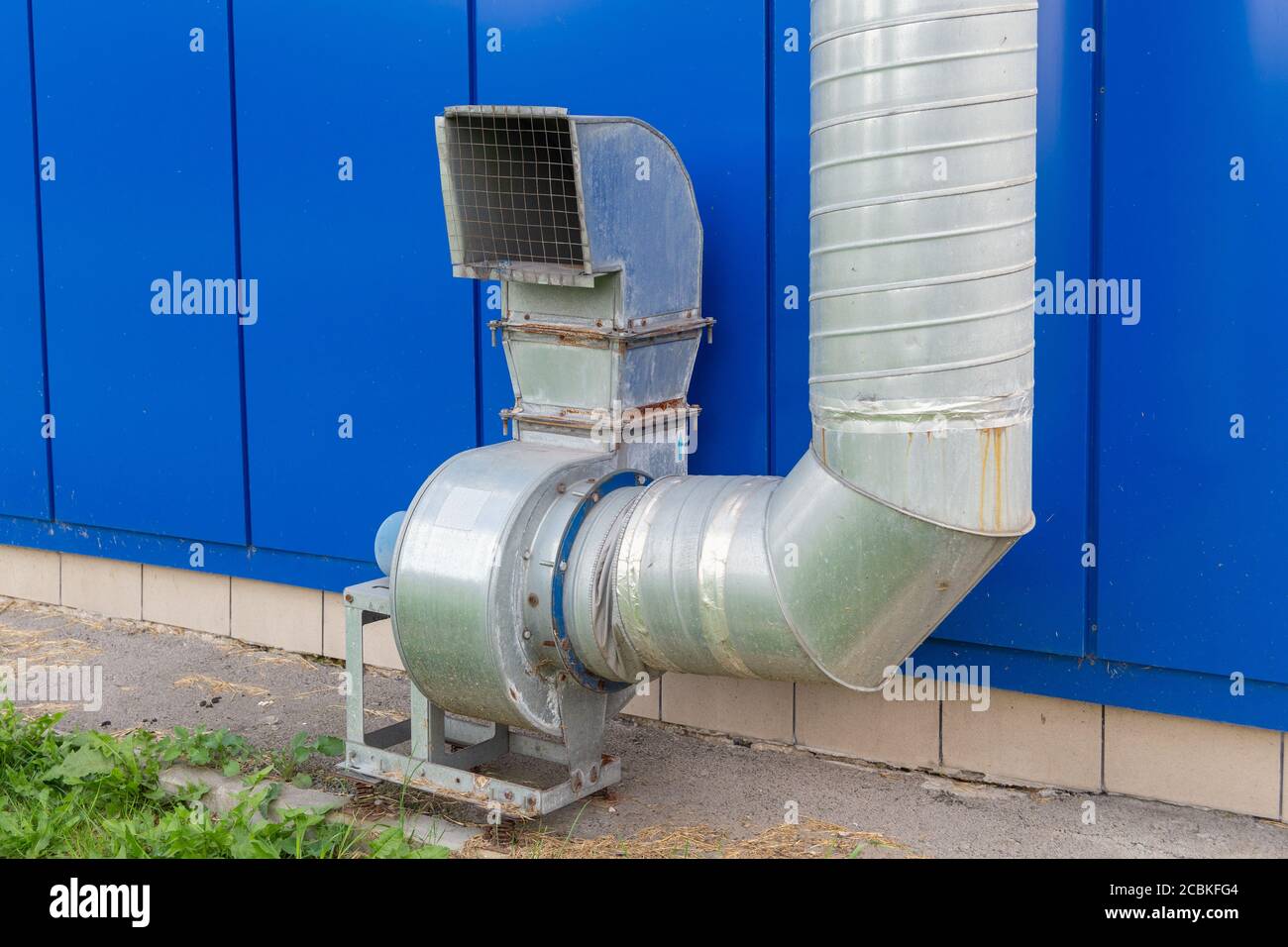 industrial grade air extraction duct with electrical motor on blue wall ...