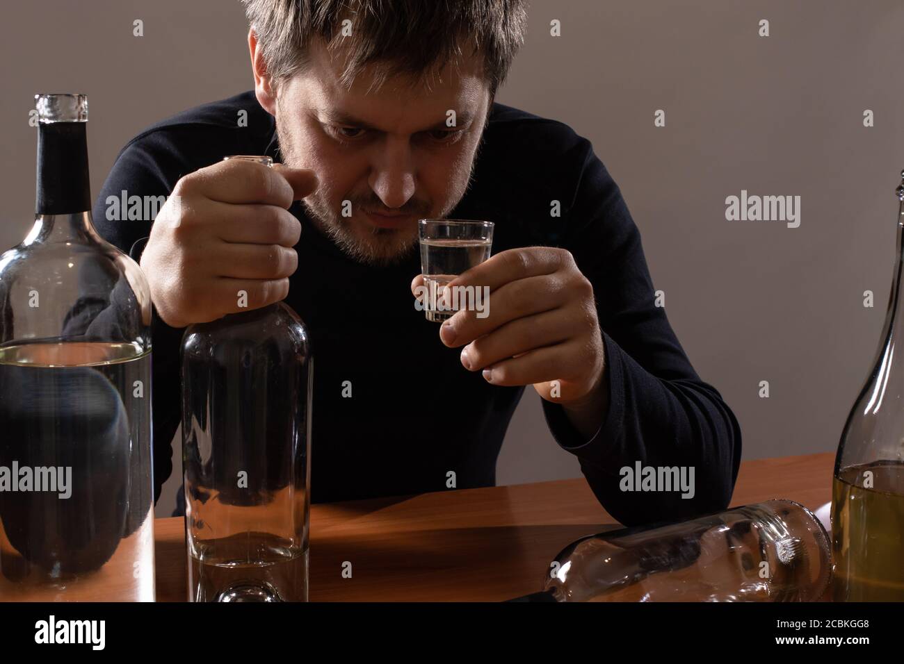 A man in alcoholic intoxication holds a glass of alcohol. Alcoholism ...