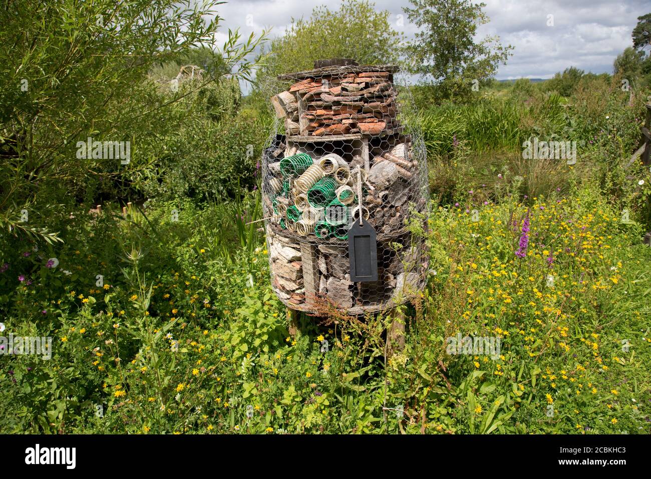 Large insect hotel built from old clay pipes, pastic corrugate tube ...