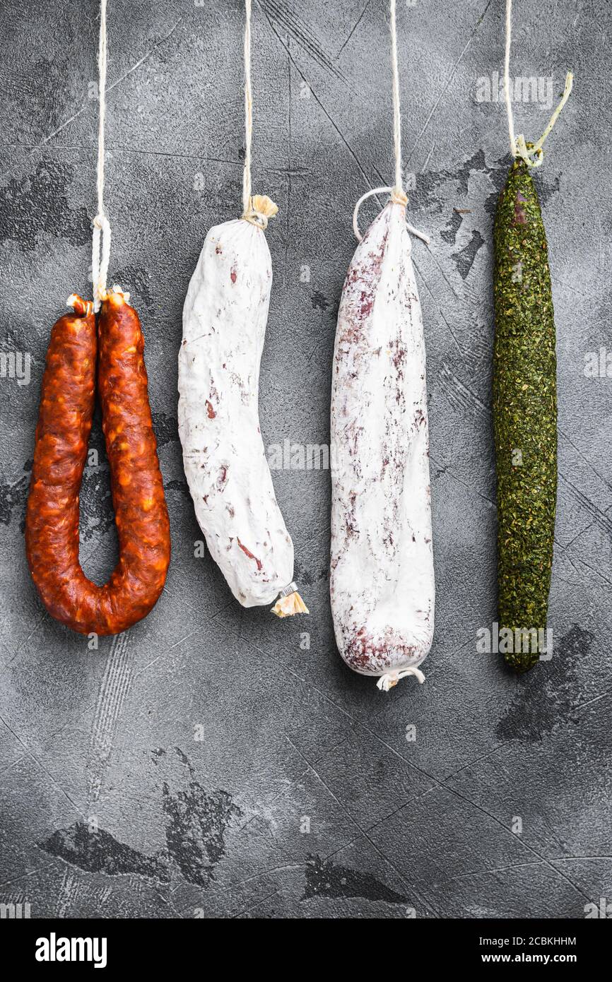 Spanish dry salami from a rack at market on grey textured background ...