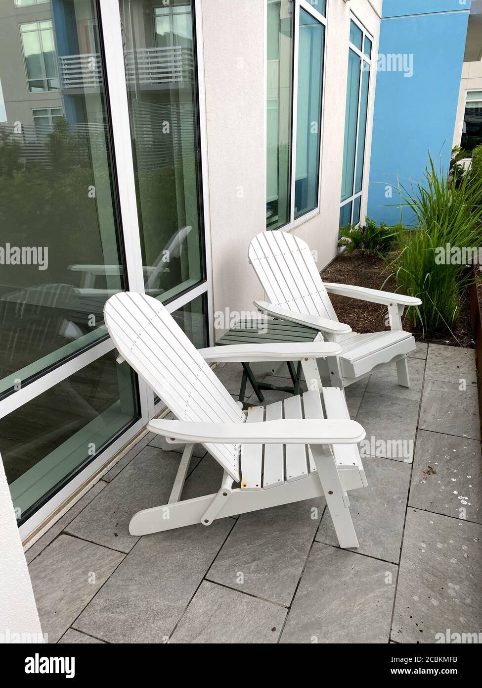 Two adirondack chairs sitting on a patio. Concept peaceful, mindful ...