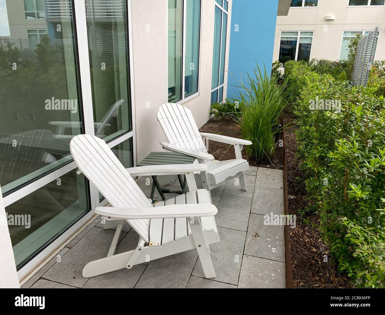 Two adirondack chairs sitting on a patio. Concept peaceful, mindful ...