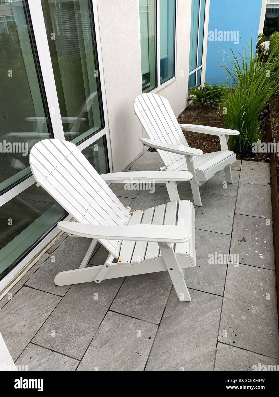 Two adirondack chairs sitting on a patio. Concept peaceful, mindful ...
